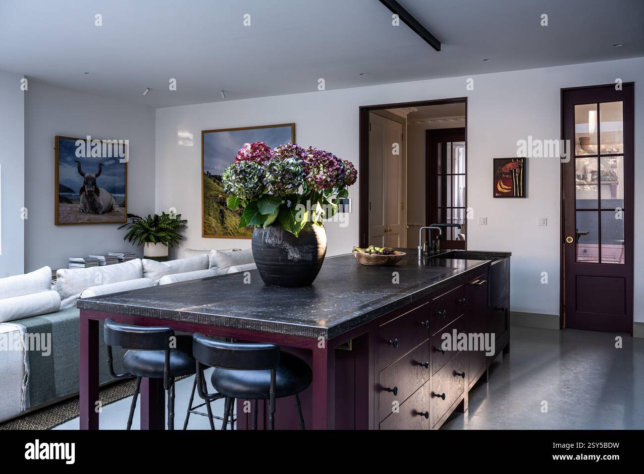 Large vase of hydrangeas with bar stools by Rose Uniacke on aubergine ...