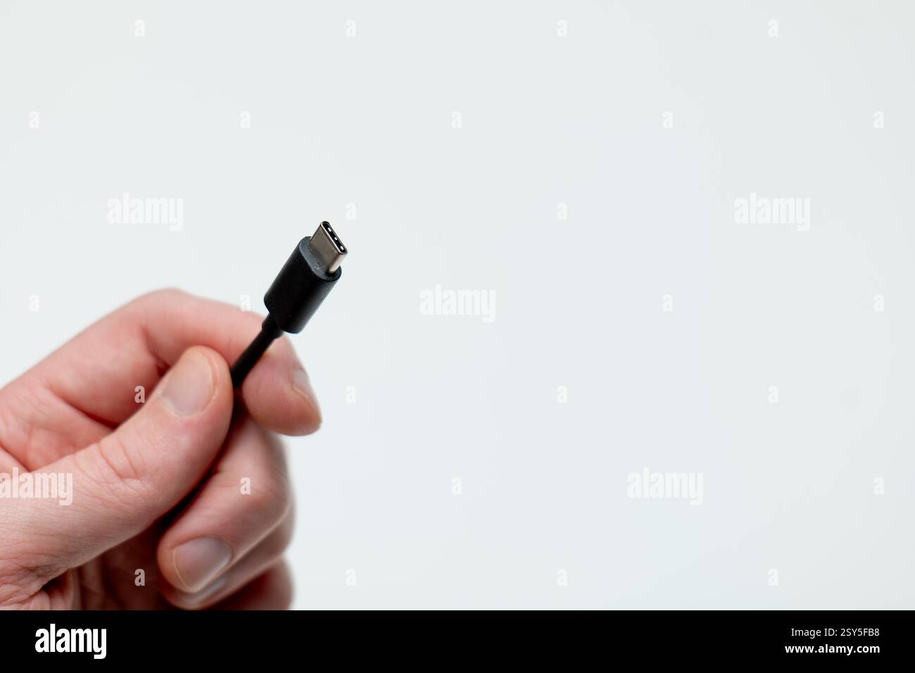 hand holding usb-c wire on white background Stock Photo - Alamy