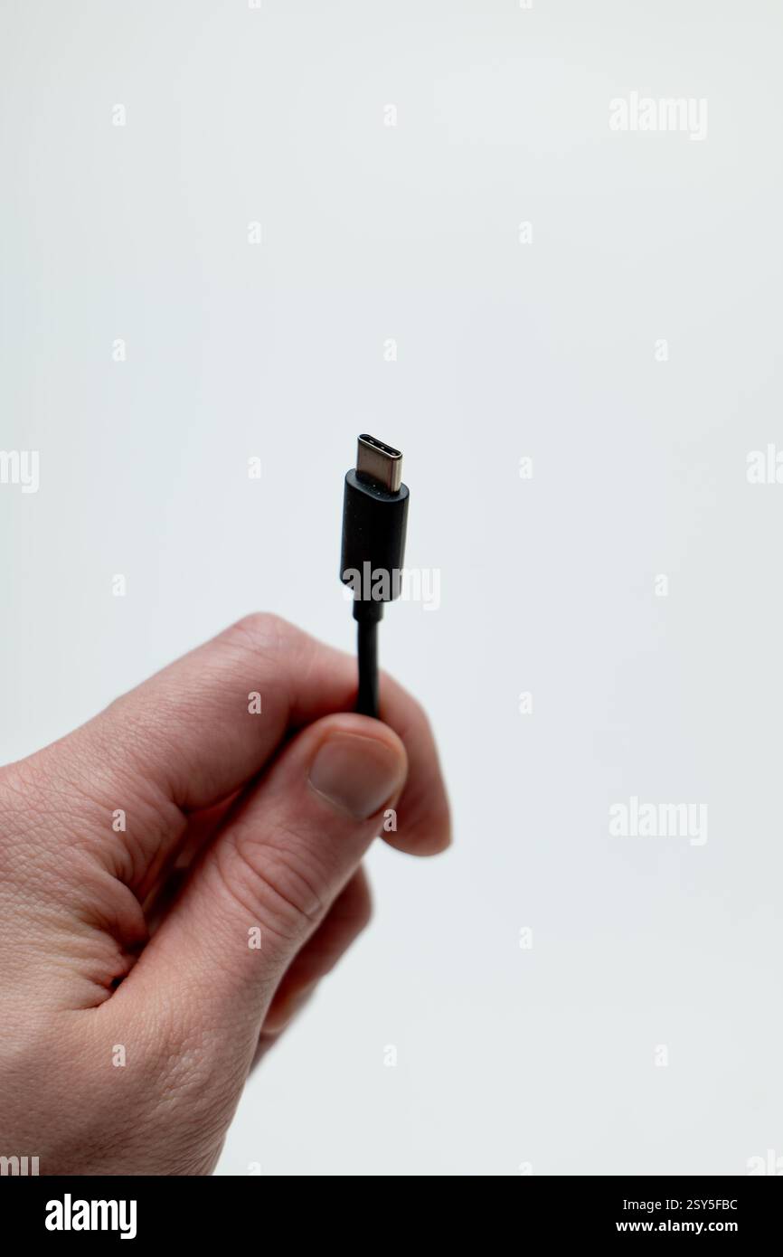 hand holding usb-c wire on white background Stock Photo - Alamy