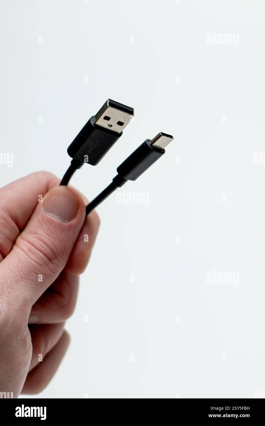 hand holding usb-c wire on white background Stock Photo - Alamy