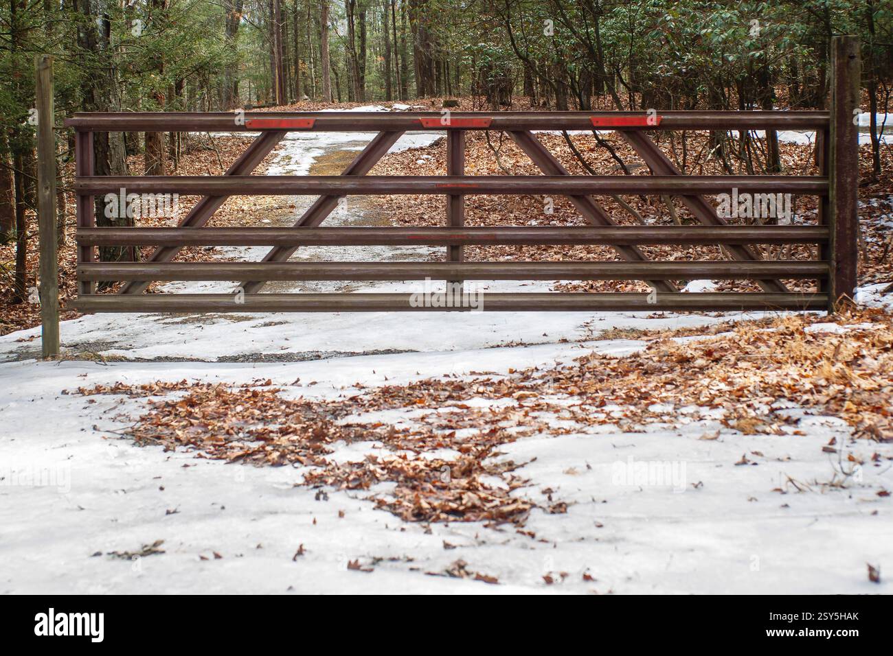 Locked rusted metal gate across a path Stock Photo - Alamy