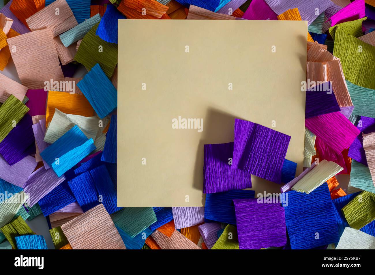 A pile of colorful craft paper with a blank sheet of paper for creative ...