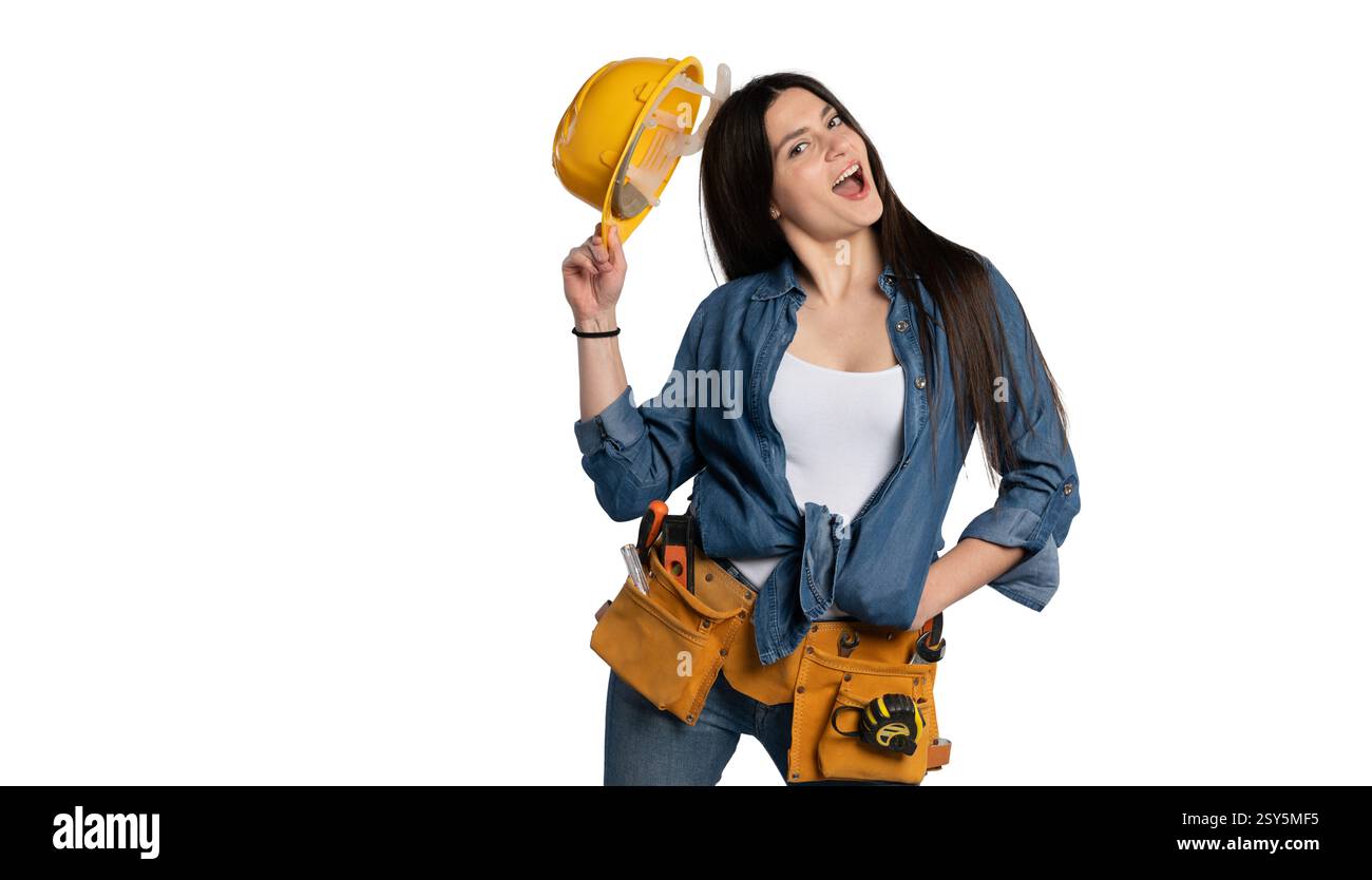 A cheerful female construction worker wearing a denim shirt, white tank top, and tool belt ...