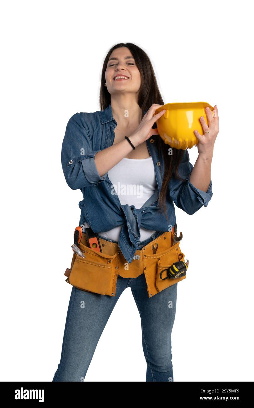 A cheerful female construction worker wearing a denim shirt, white tank ...