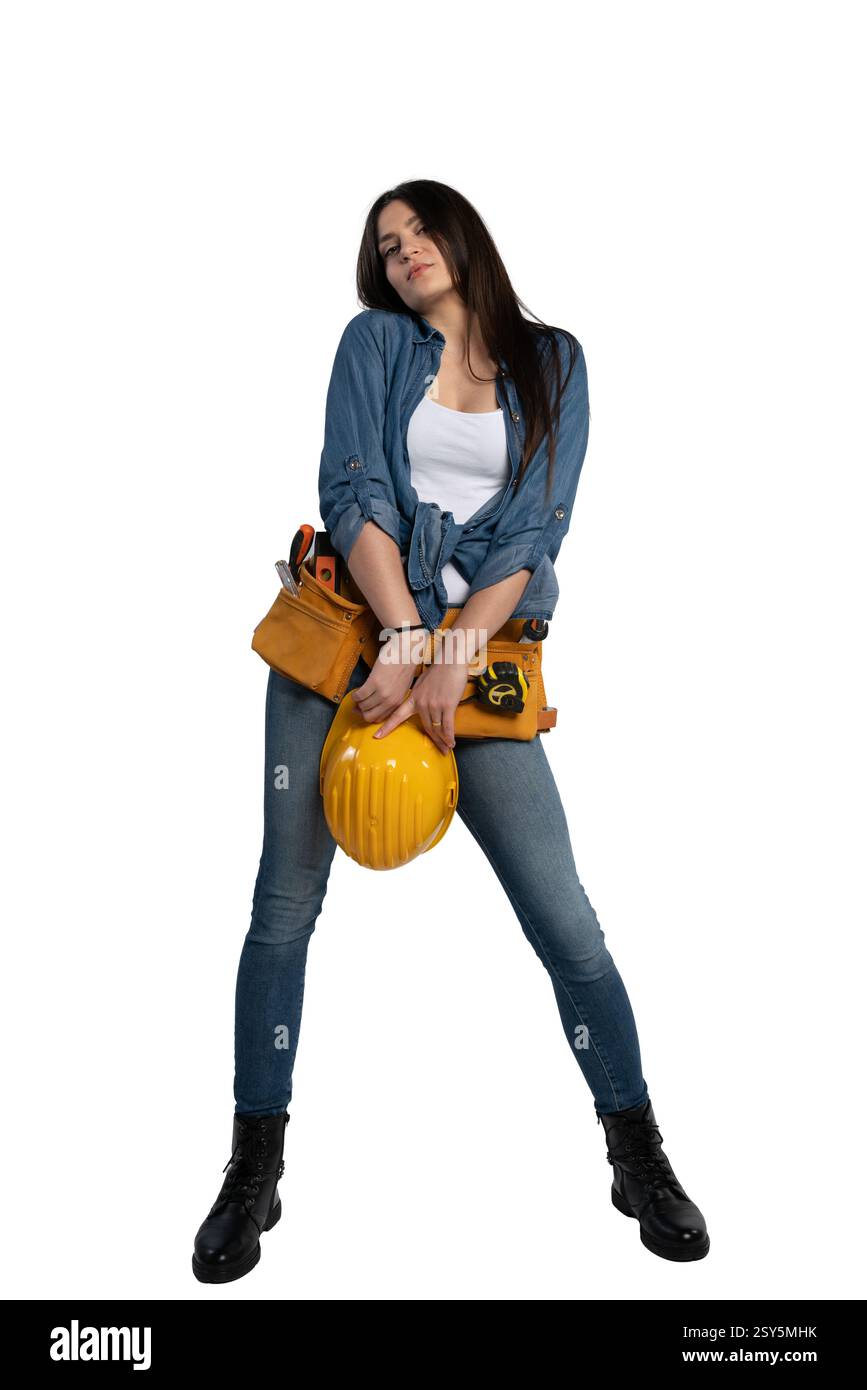 A young female construction worker dressed in a denim shirt, white tank ...