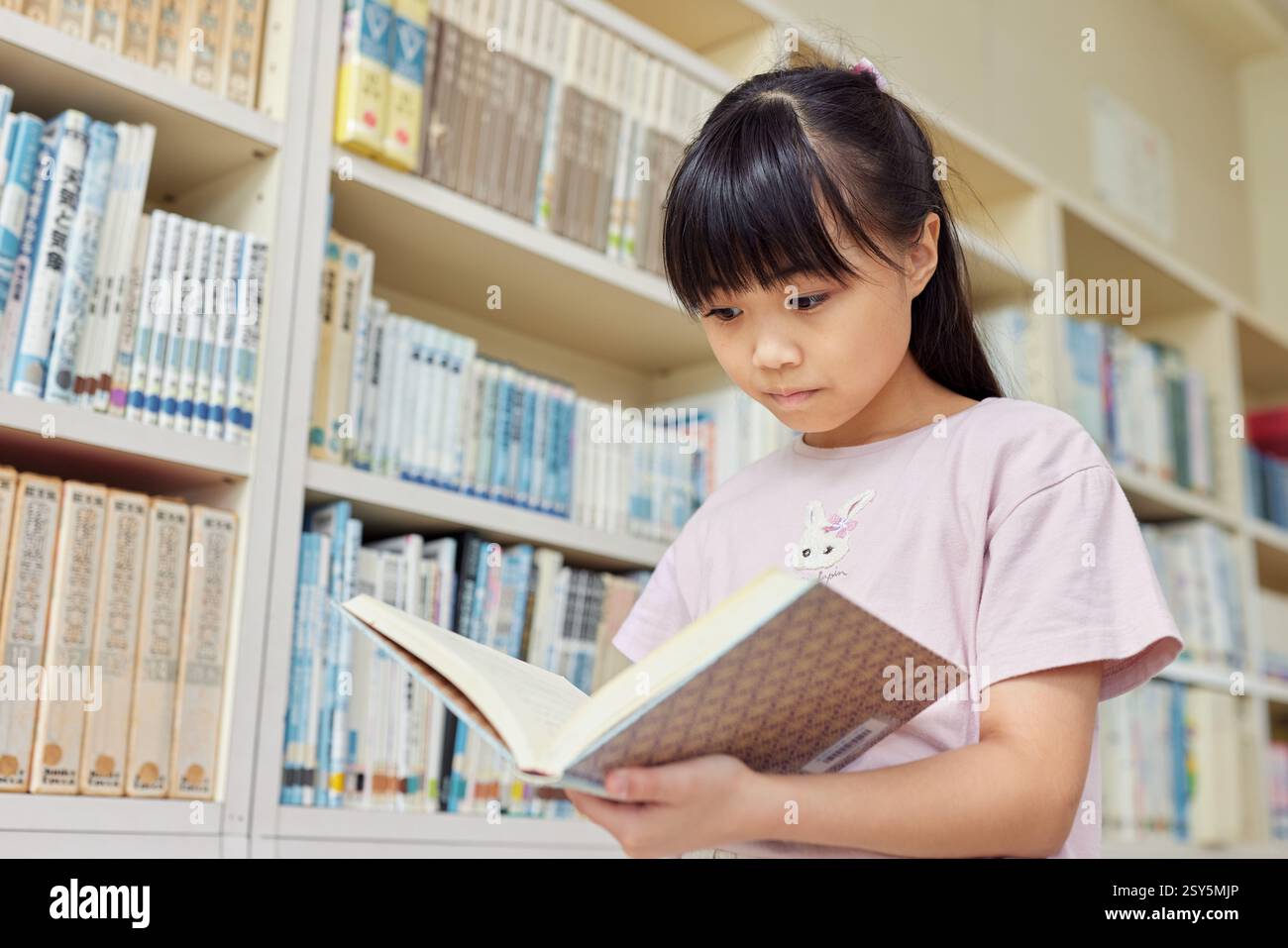 Asian girl reading library hi-res stock photography and images - Alamy
