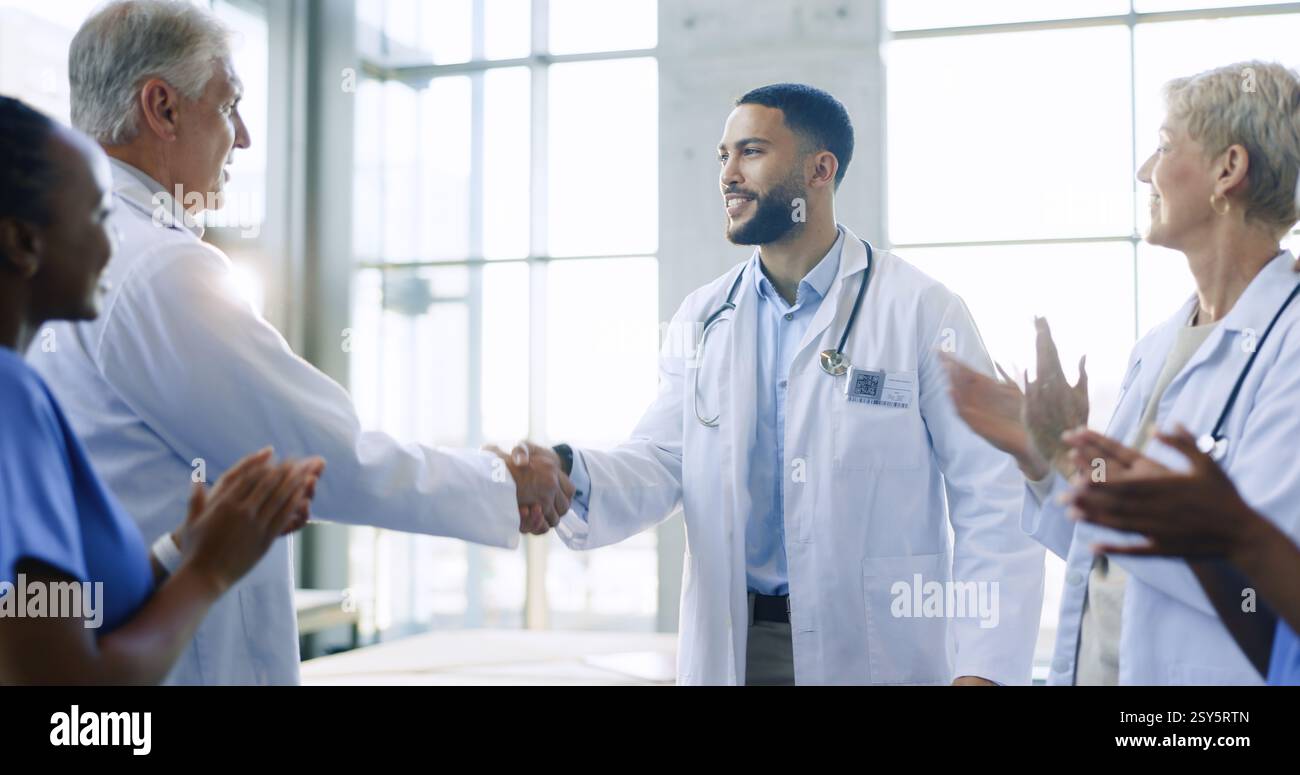 Healthcare, applause and handshake by doctors in a hospital with partnership, success or deal ...
