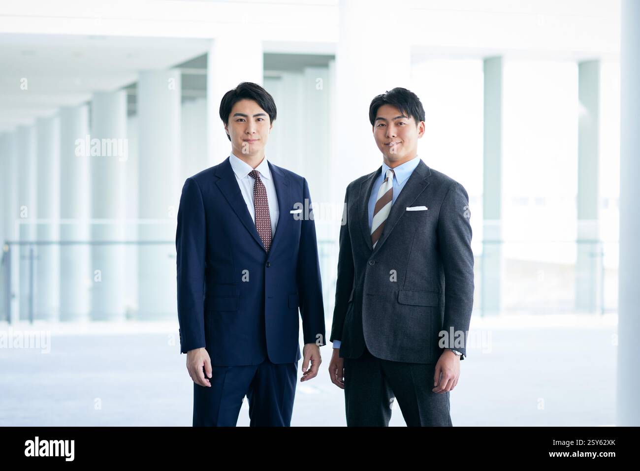 Two Japanese Businessmen In Suits Standing Next To Each Other Stock ...