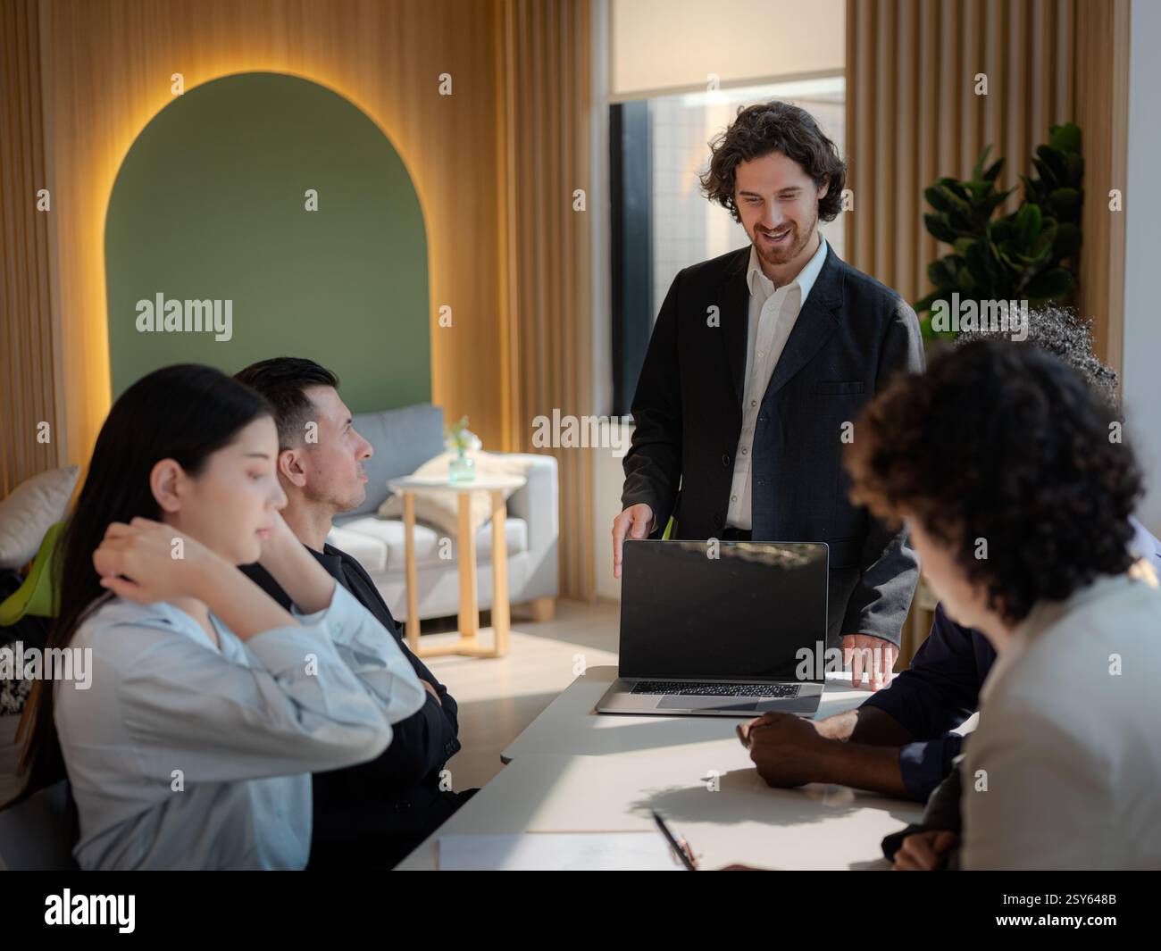 Group of coworkers collaborating and brainstorming together in a ...