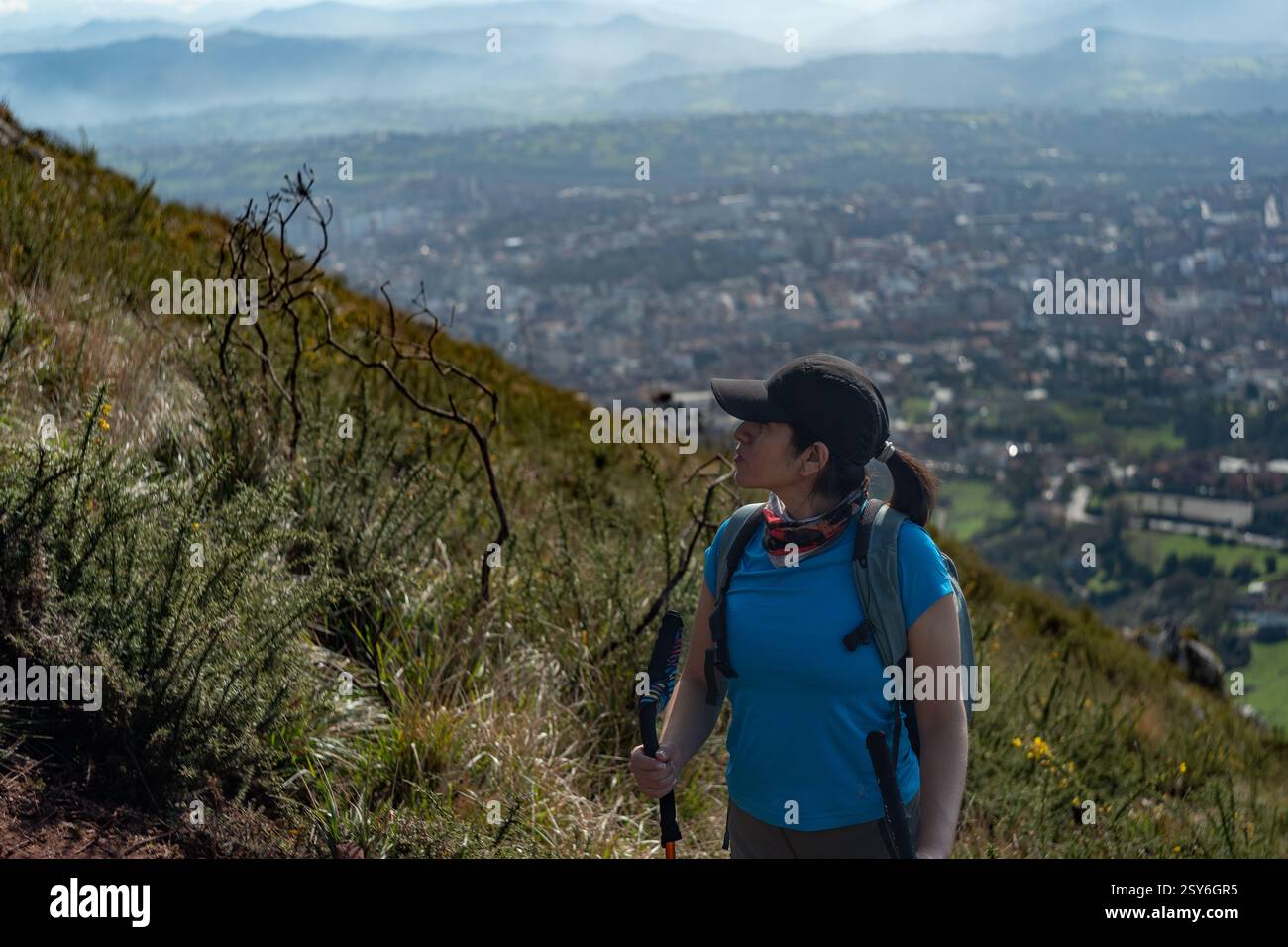Woman takes a break on her climb up Naranco Mountain in Oviedo, Spain ...