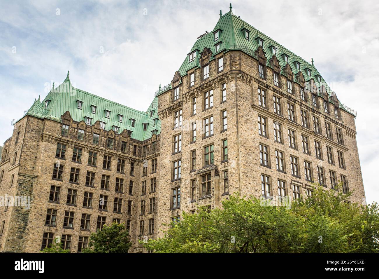 Large building with a green roof. The building has a lot of windows and ...