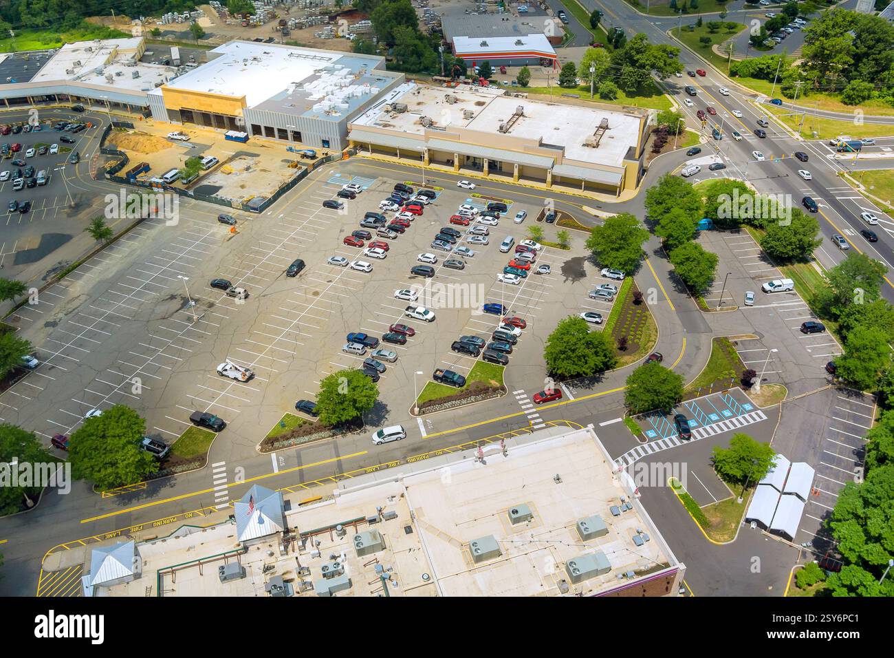 Vehicles occupy spaces in large parking lot surrounded by retail ...