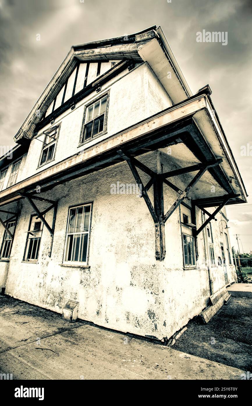 Large white building with a slanted roof. The building has a lot of ...