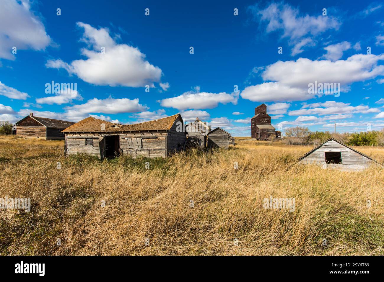 Vast, dry field with several old, dilapidated buildings scattered ...