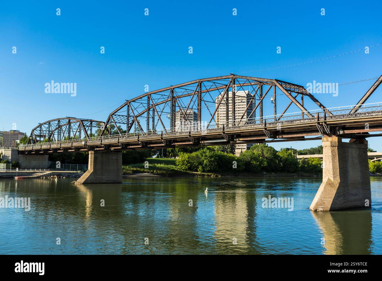 Bridge over a river with a reflection of the bridge in the water. The ...