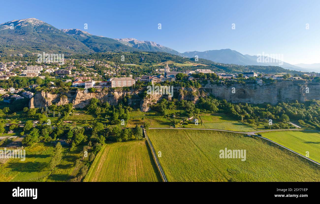 Embrun, France, and its cliff Le Roc in the French Alps. Aerial view of ...