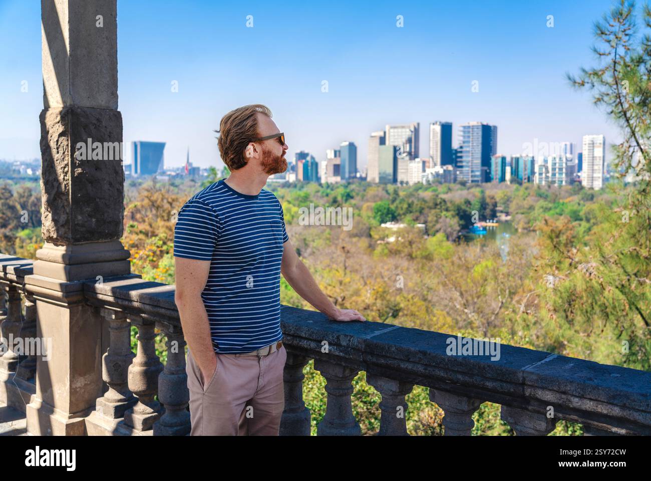 A tourist man standing at a terrace overlooking the Chapultepec Forrest ...