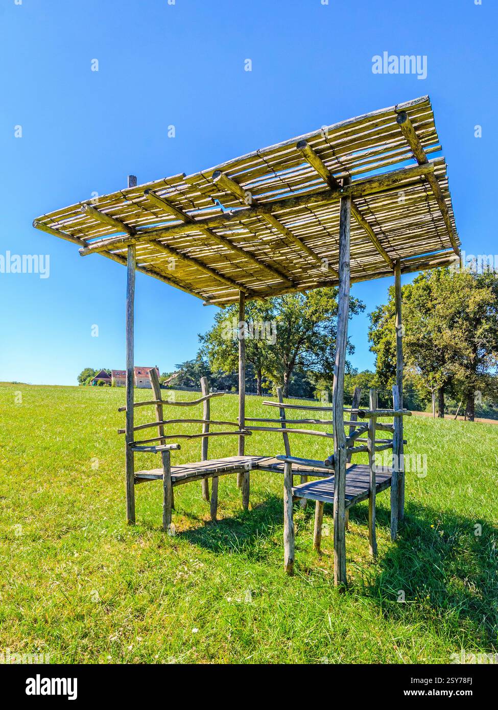 Rustic wooden seating and picnic area on hillside above the village of ...