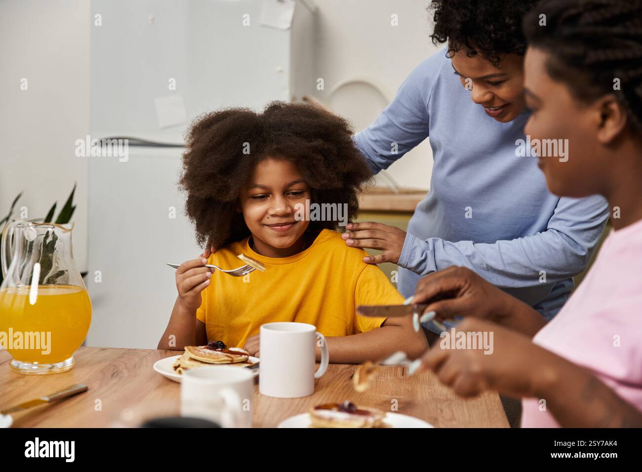 An LGBT family shares a joyful breakfast with their daughter, smiling ...