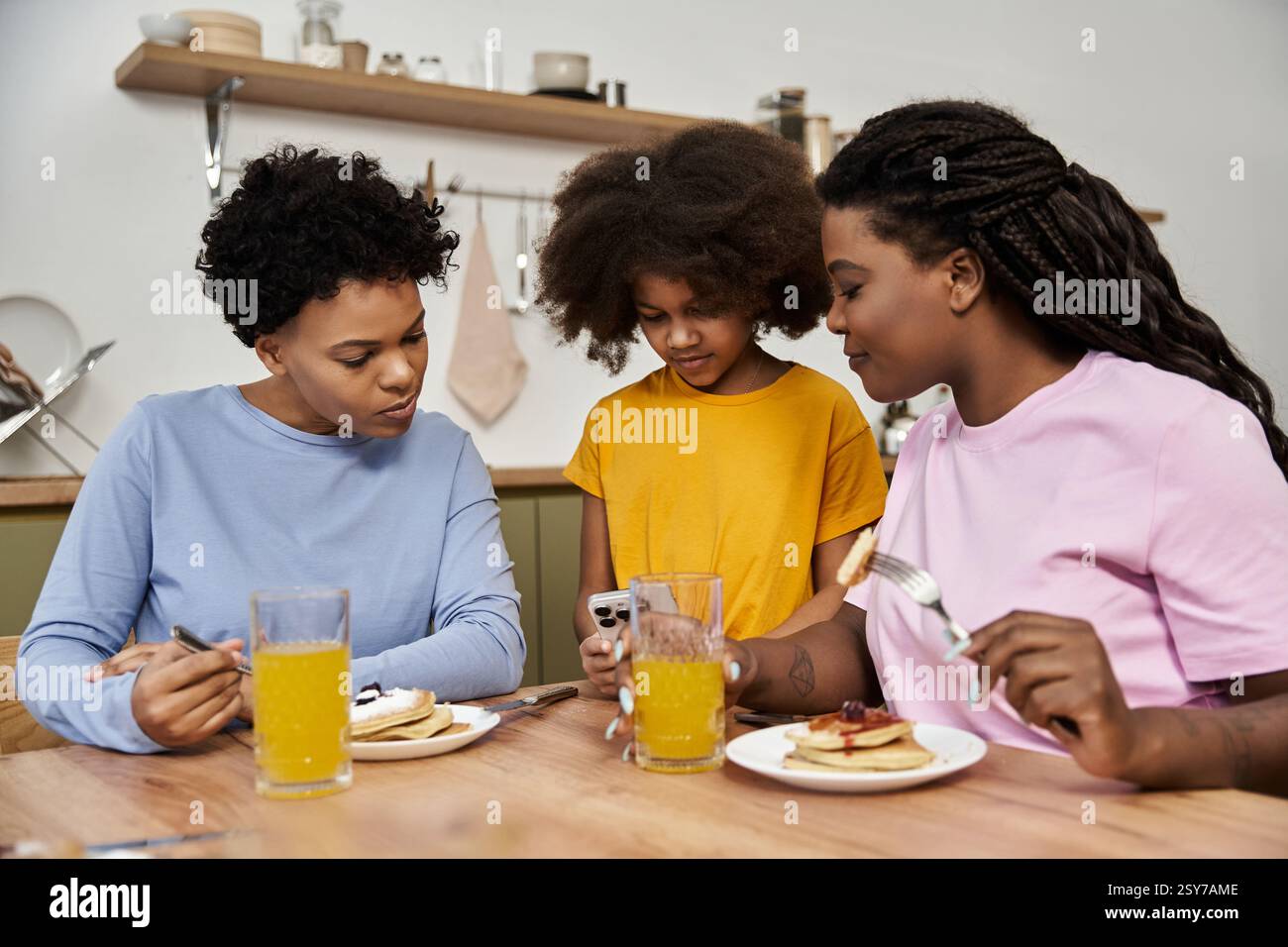 Three family members savoring breakfast and bonding over shared moments ...