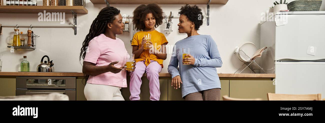 Three family members share laughter and drinks while bonding in a warm ...