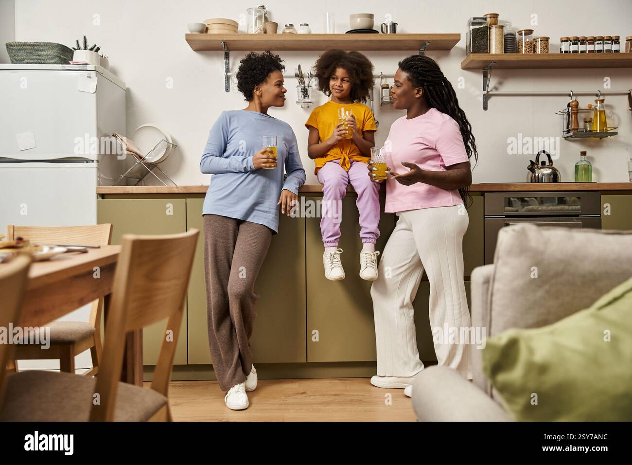 Three family members share laughter and drinks, enjoying quality time ...