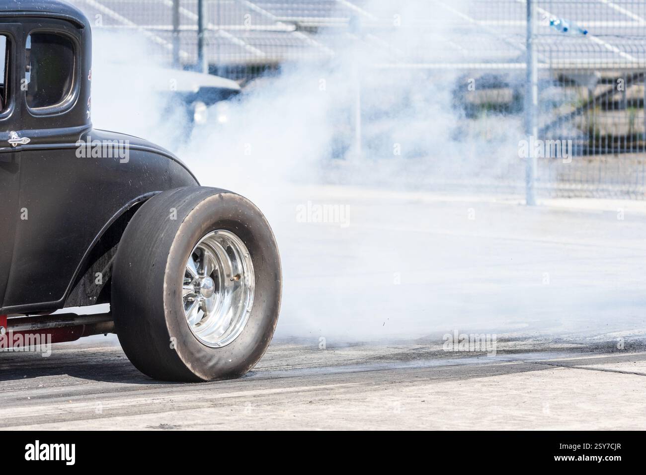 Smoke from under the wheels of a hot rod on the starting line Stock ...