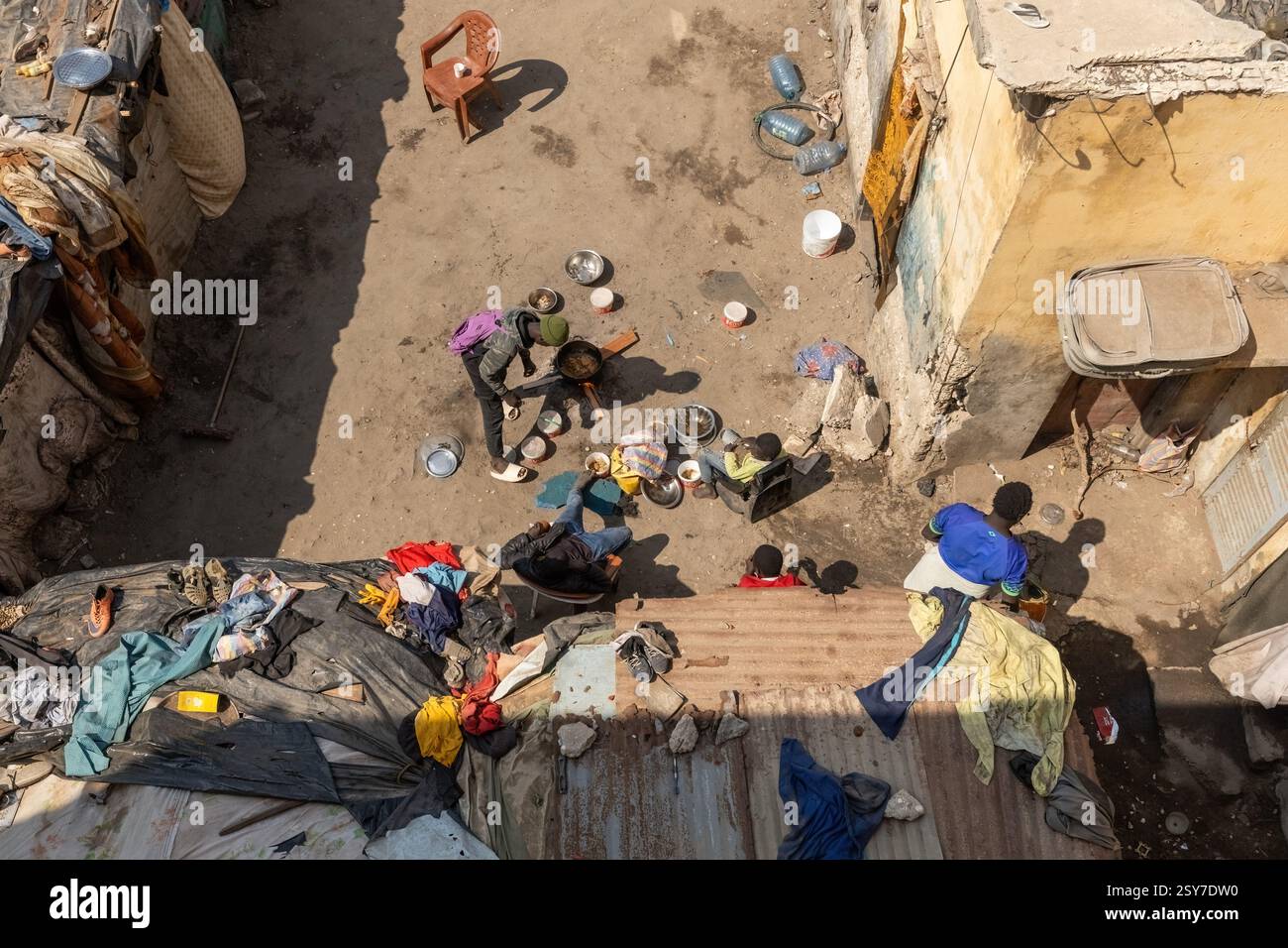 Top view of the poor family cooking food in the house yard on the fire ...