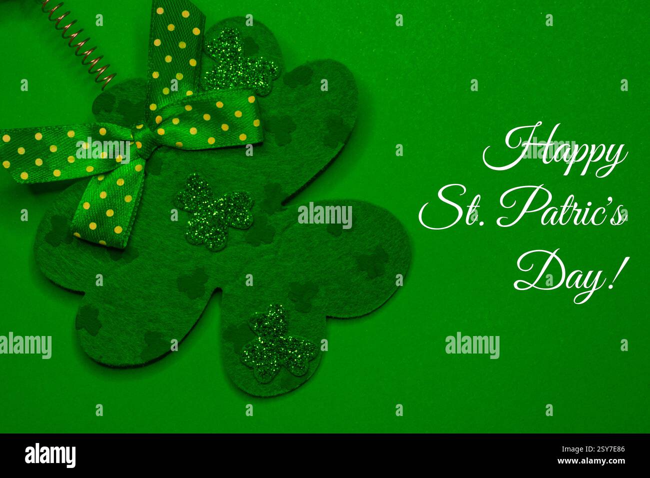 Shamrock with polka dot bow isolated on vivid green background with ...