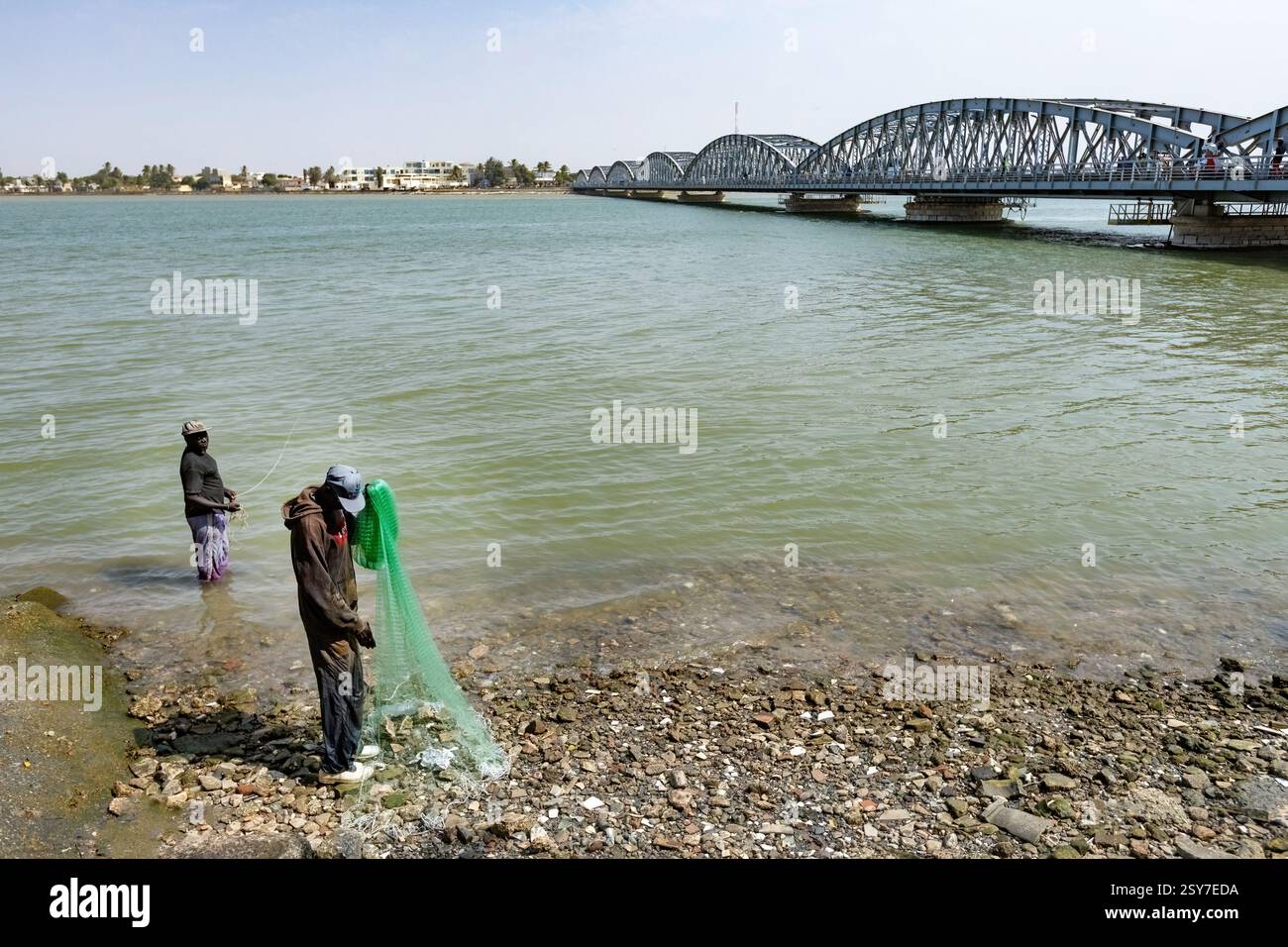 African fisherman with a fishing nets on the beach in St. Louis Senegal ...
