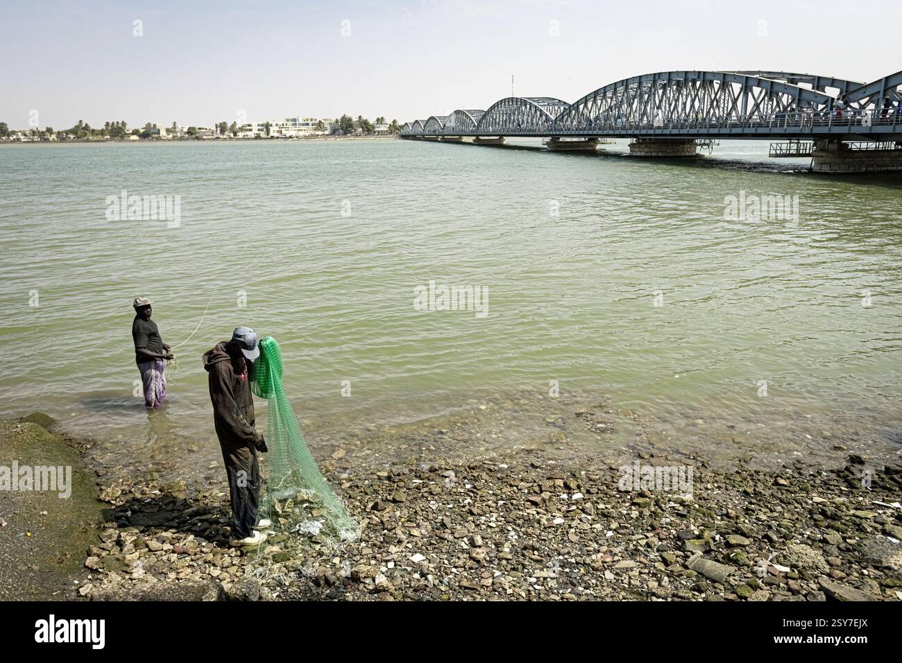 African fisherman with a fishing nets on the beach in St. Louis Senegal ...