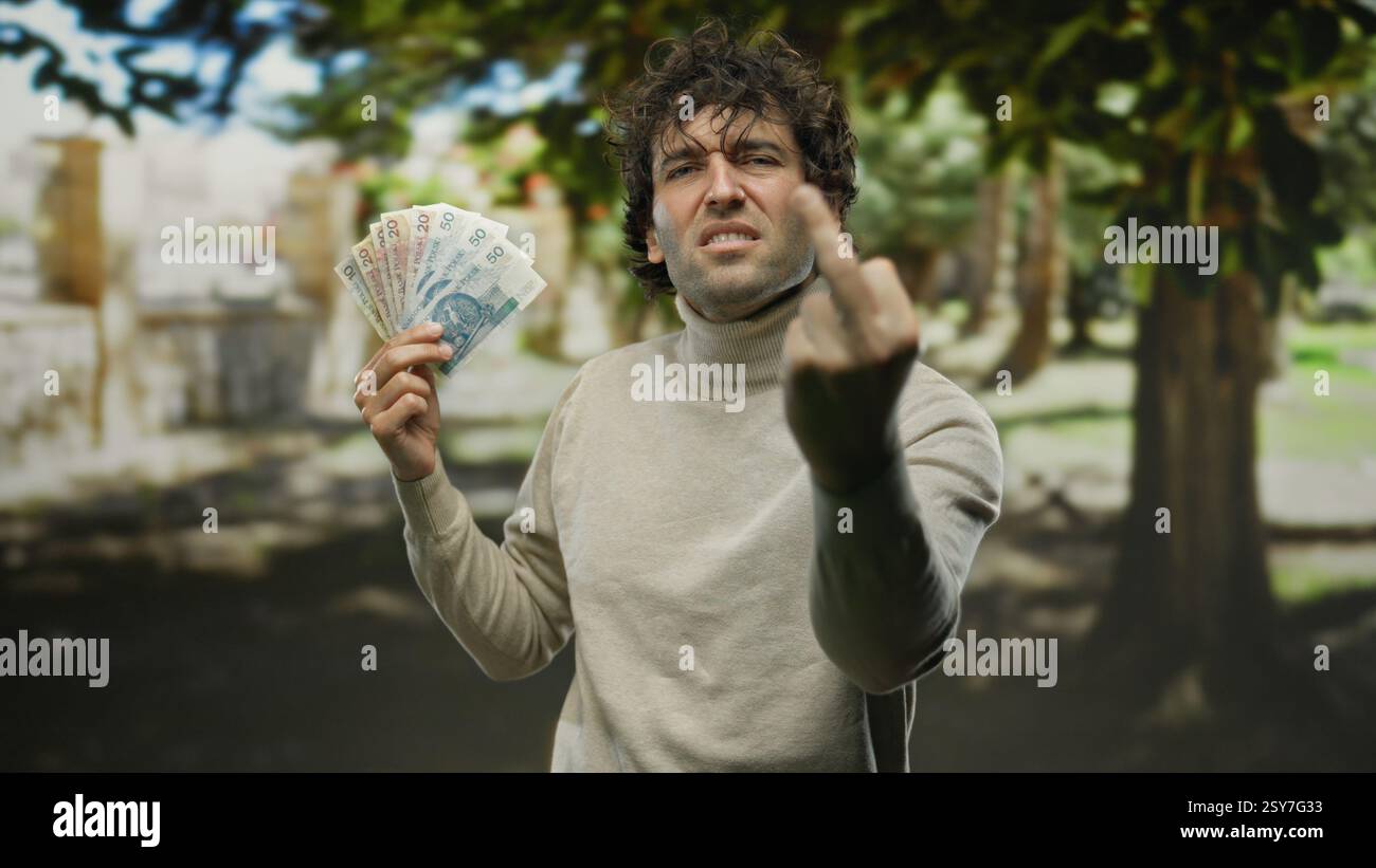 Hispanic man outdoors in a park holding polish zloty banknotes with an ...