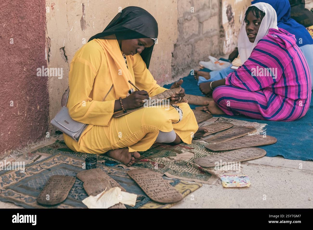 Young african woman wearing traditional clothes writing islamic holy ...