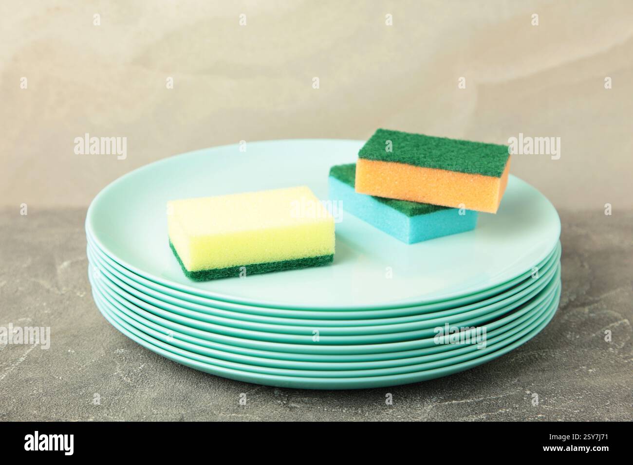 Cleaning sponge with plate on grey concrete background. Vertical photo ...