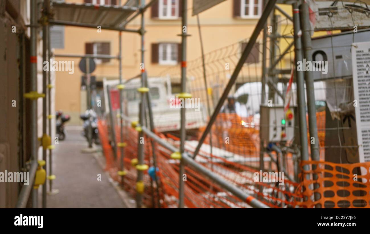 Blurred construction site with scaffolding and safety barriers in urban ...