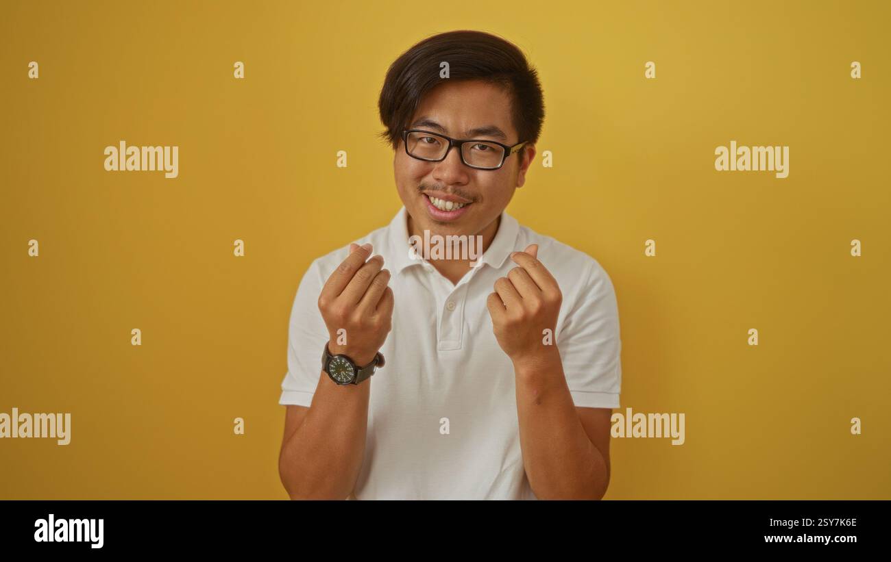 Young man from china in white shirt smiling against a yellow background ...