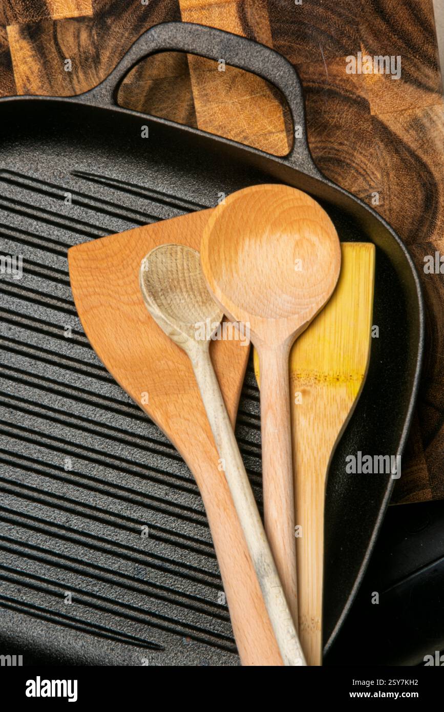Cast iron griddle pan on a wooden chopping board. You notice the rustic ...