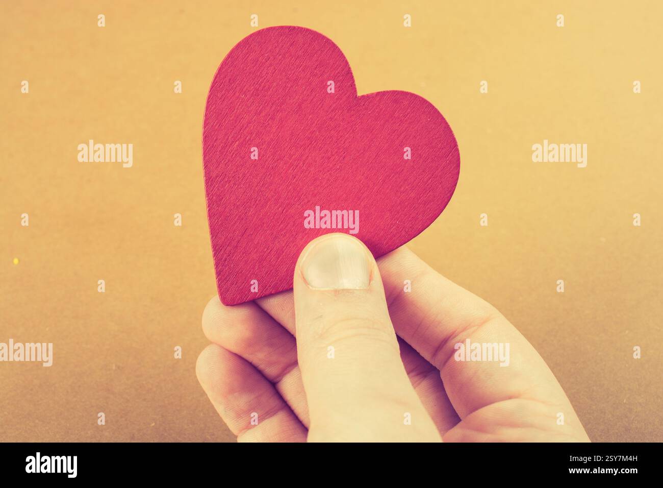 Red color heart shaped object in hand on dotted paper Stock Photo - Alamy