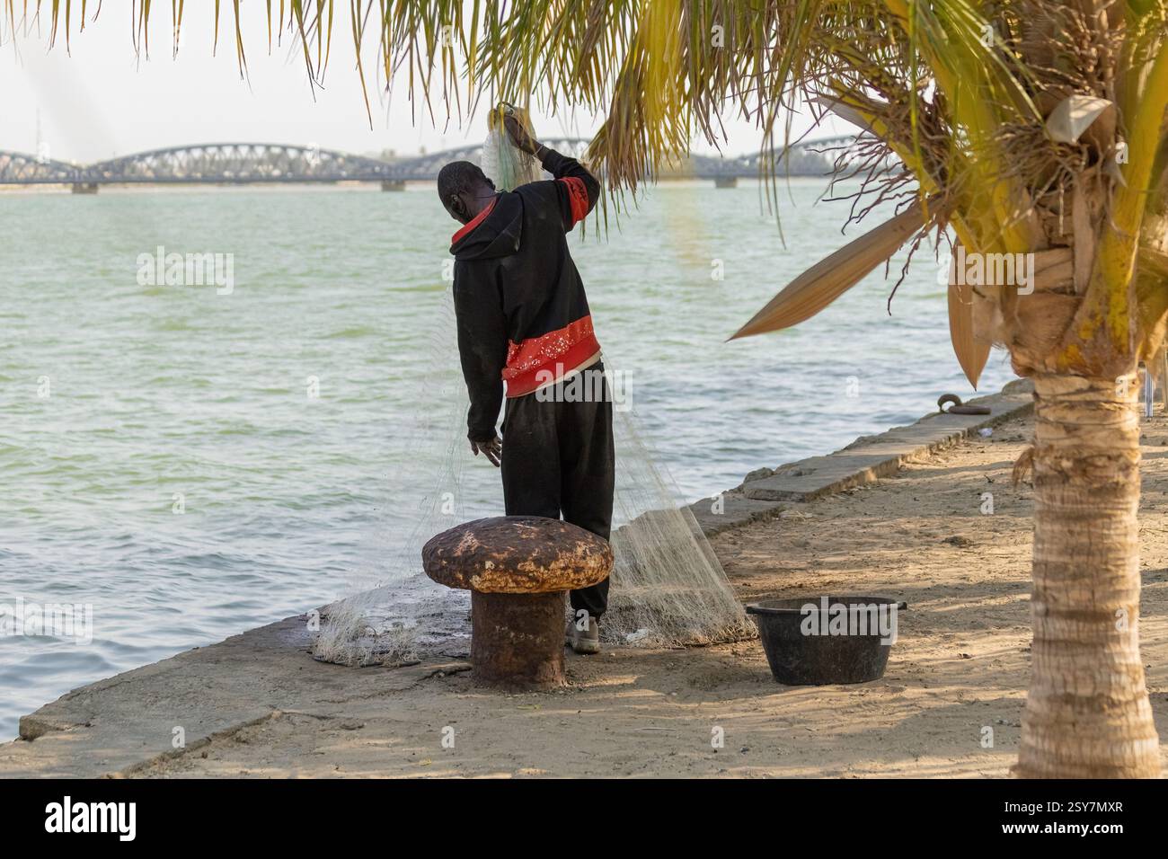 African fisherman with a fishing nets on the beach in St. Louis Senegal ...