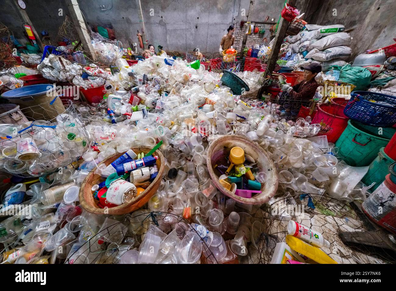 Local women sort plastic waste in a hall in the small village of Tan ...