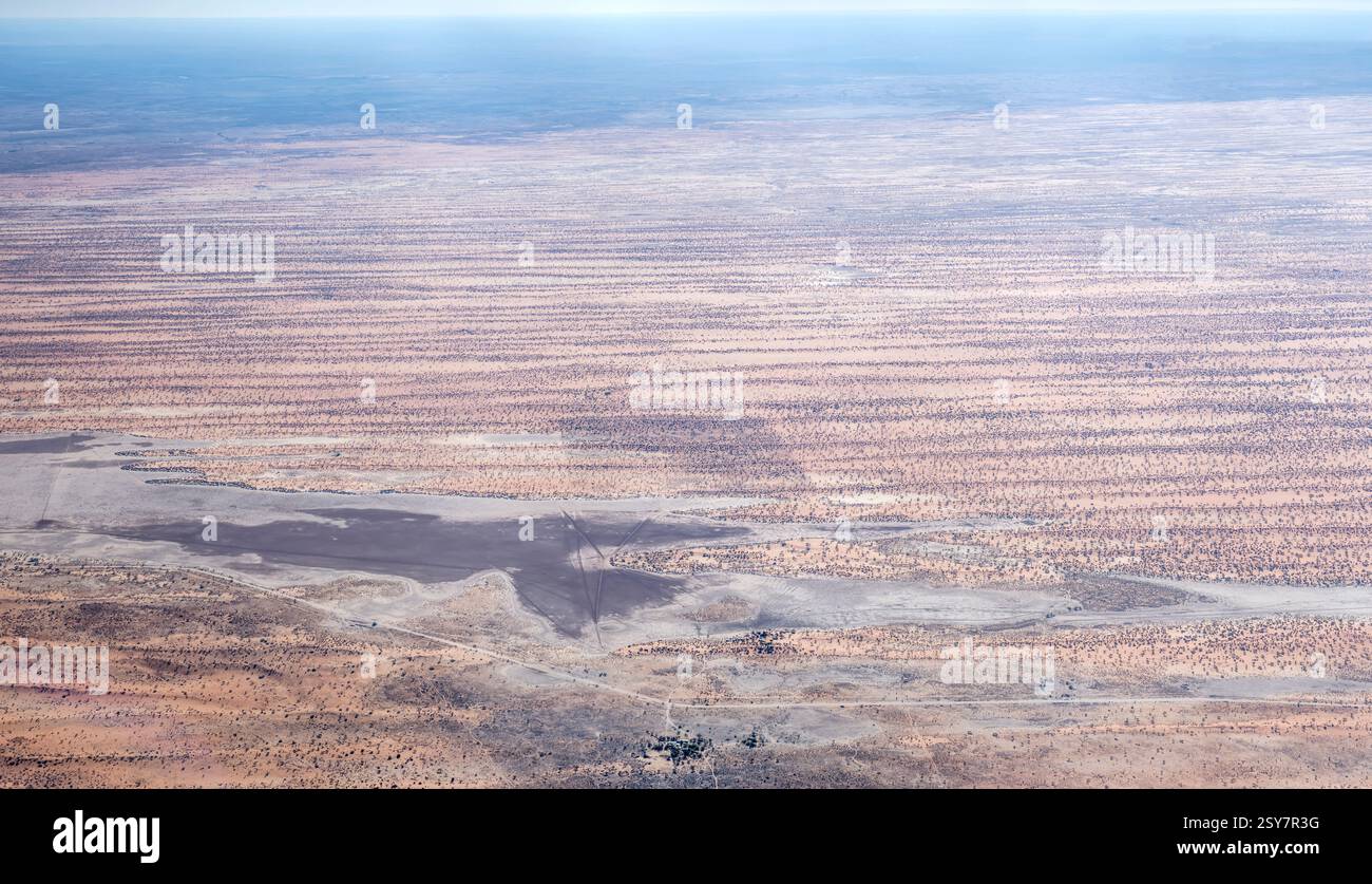 aerial landscape with stripes of red dunes and pan in Kalahari desert ...