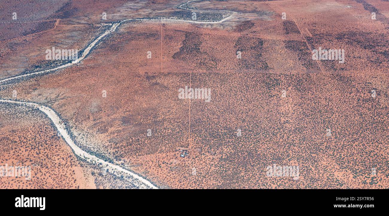 aerial landscape with dry riverbed winding in red sand and shrubs at ...