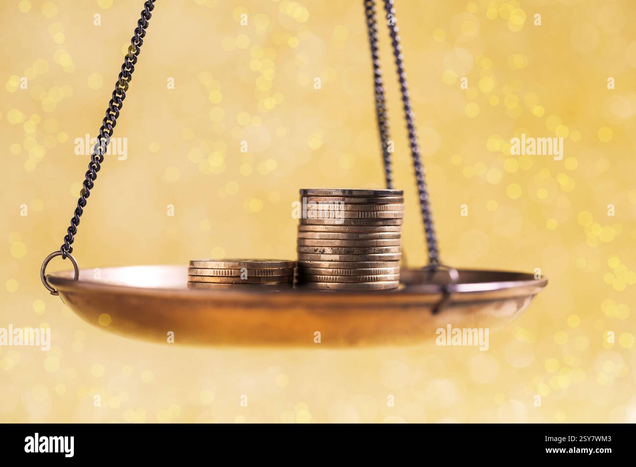 Many coins on scales against golden glitter background, closeup Stock ...