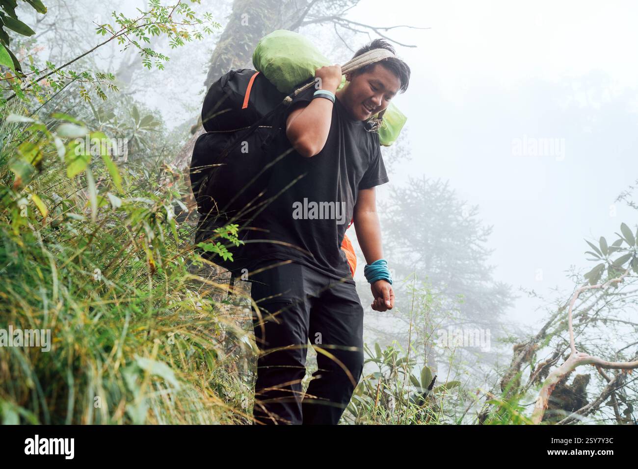 Portrait of strong Sherpa man working as porter carrying huge cargo ...