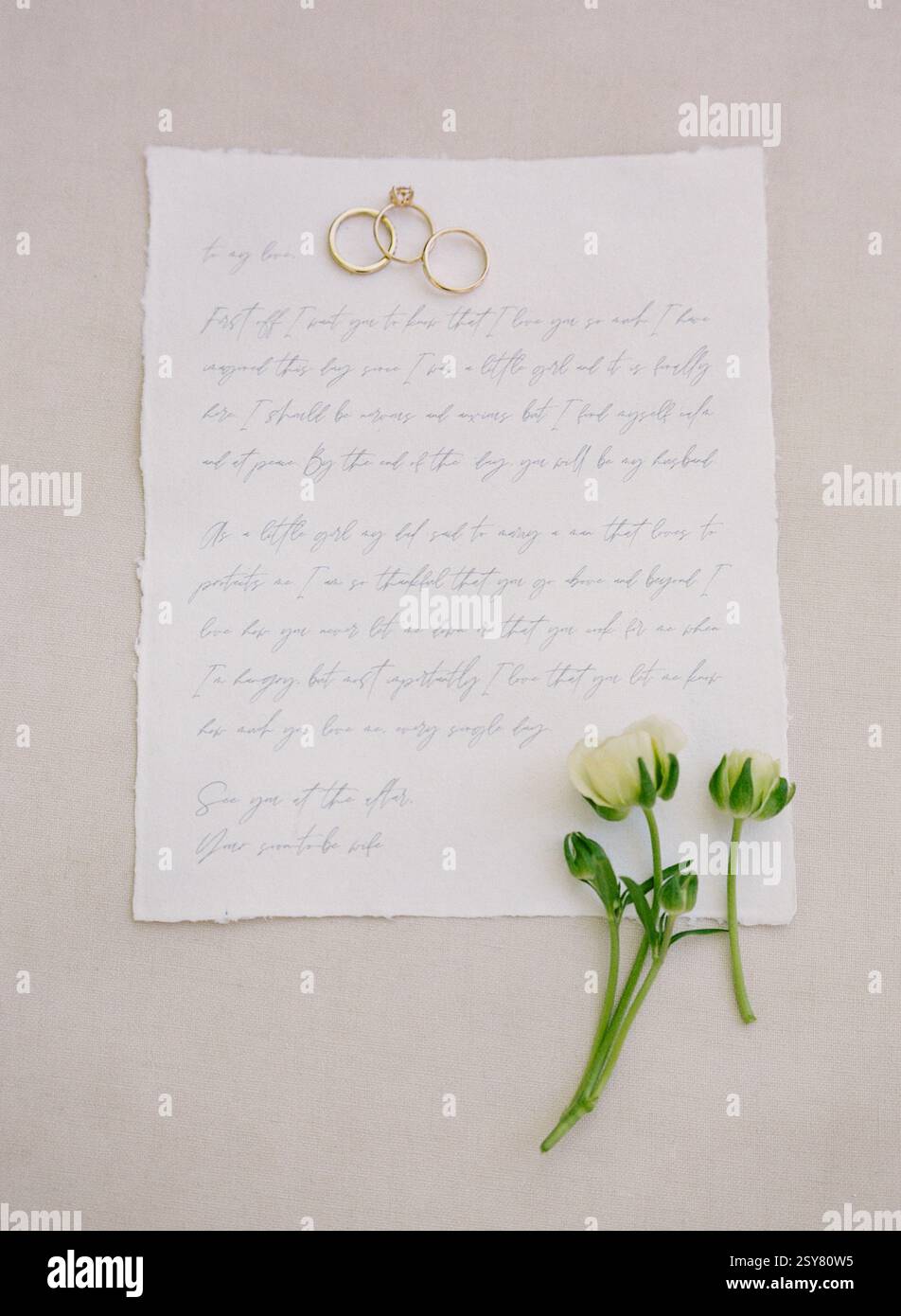 A delicate handwritten letter with rings and blooms adds an intimate ...