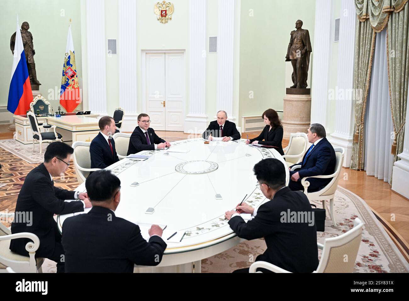 Russian President Vladimir Putin, background center, speaks with the ...