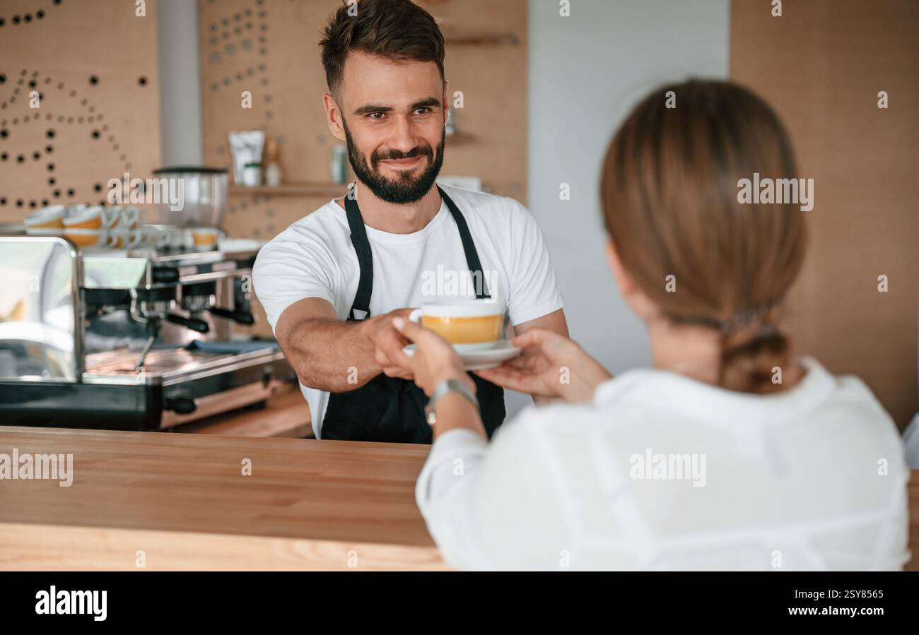 Customer takes her order from barista in the cafe Stock Photo - Alamy