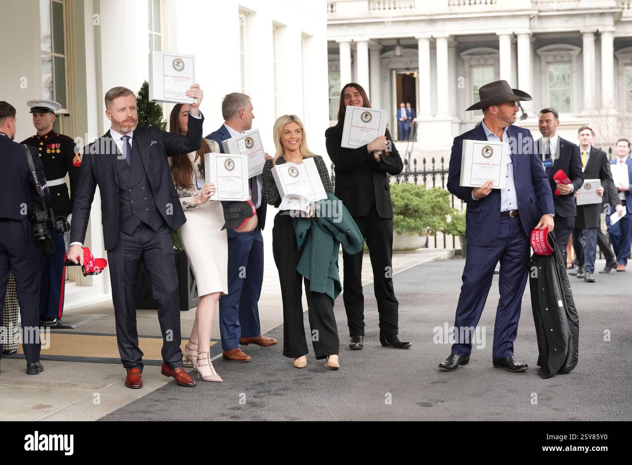 People hold binders with information on the Epstein Files outside the ...