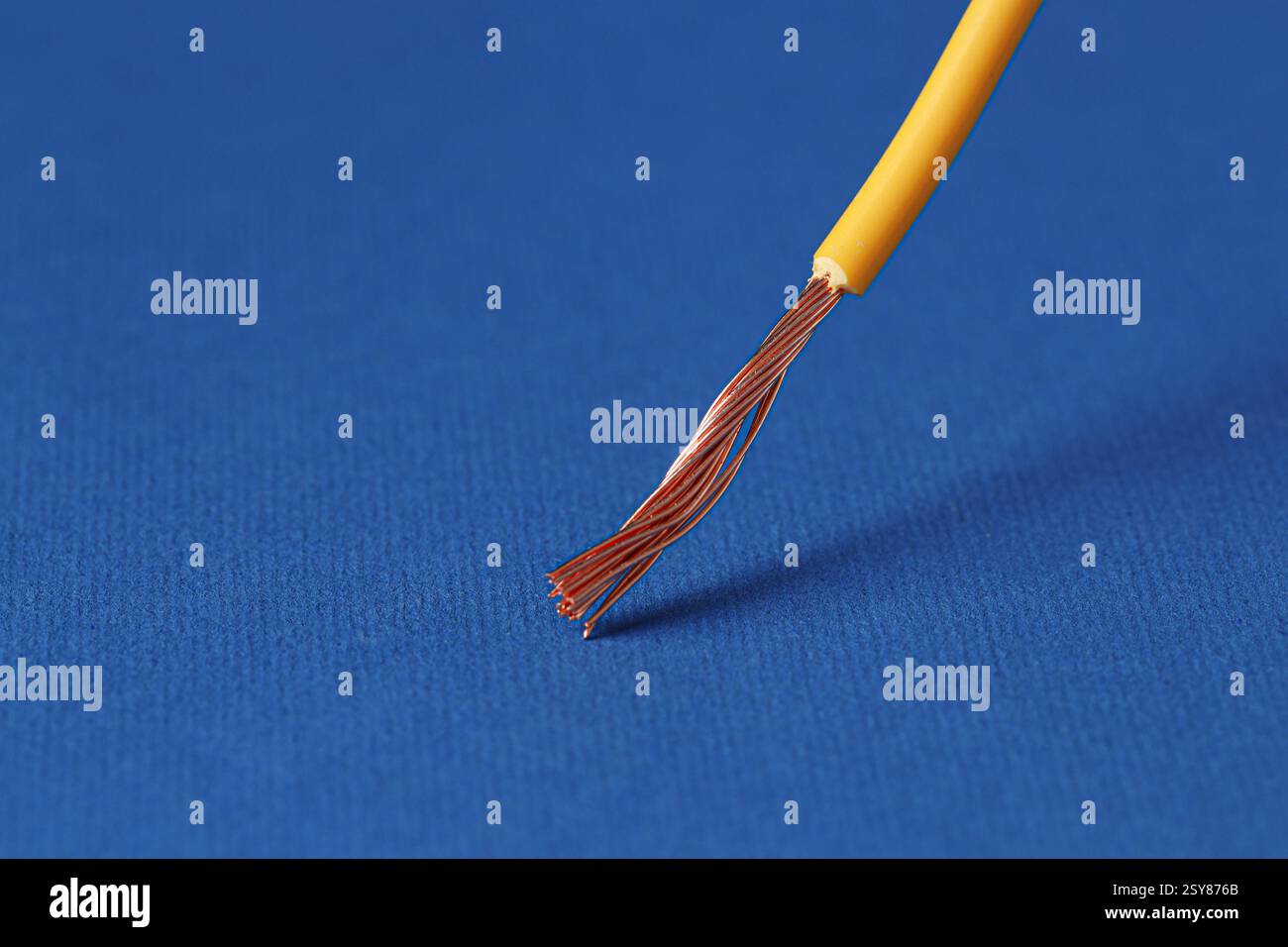 Yellow stripped electrical wire on blue background, closeup Stock Photo ...