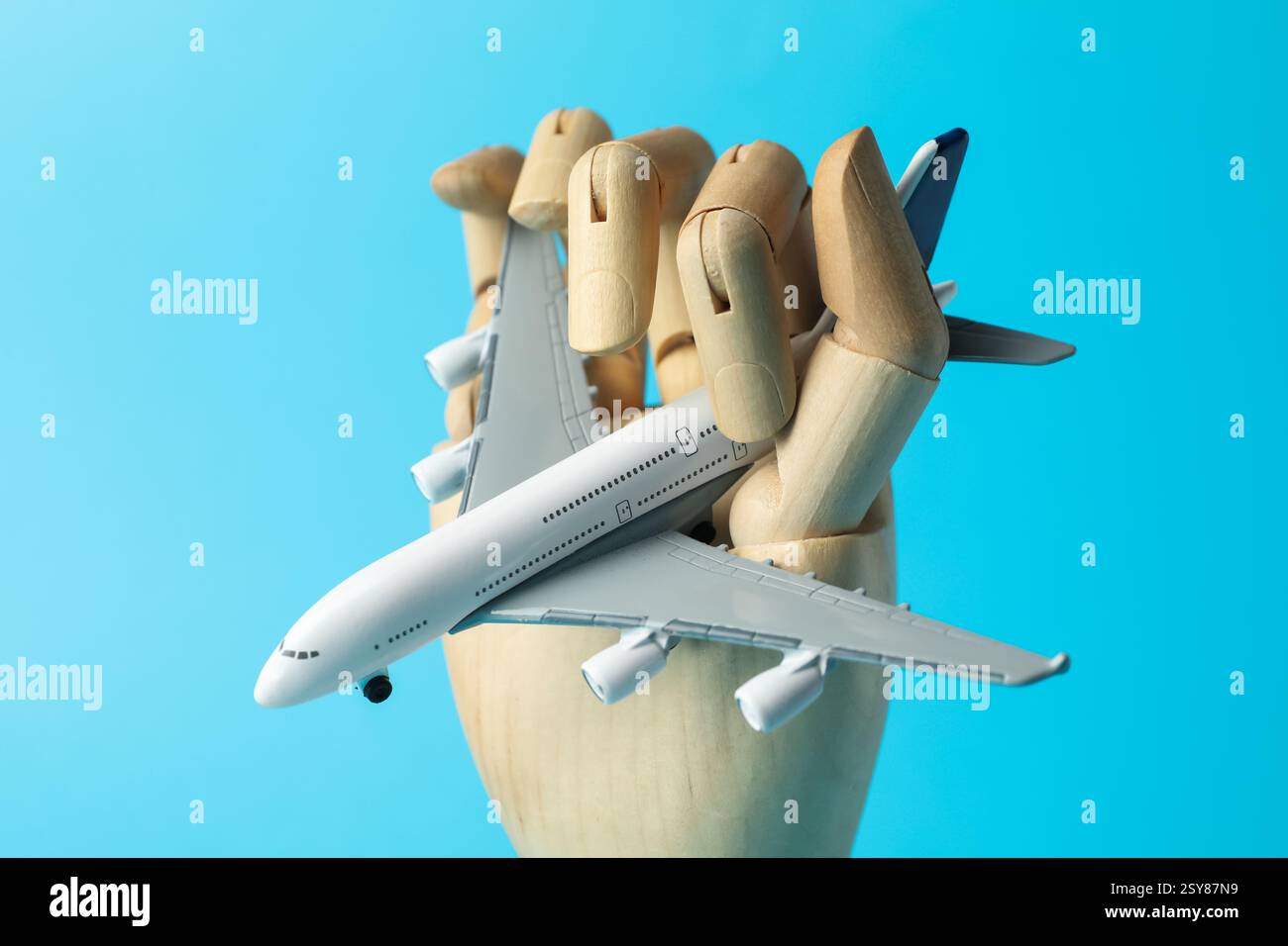 Plane model and mannequin hand on light blue background, closeup Stock ...
